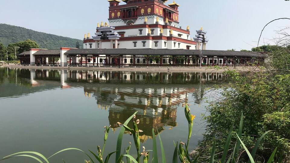 This is a picture of the Lingshan Shengjing Tibetan Buddhist inspired museum at the Ling Shan Scenic area near Wuxi, China. It sits on a small island in a small lake.