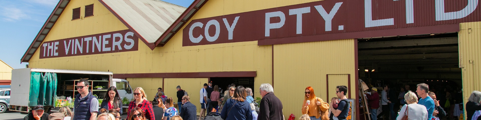 Barossa Farmers Market showing outdoor eating and signage as well as a small group of people