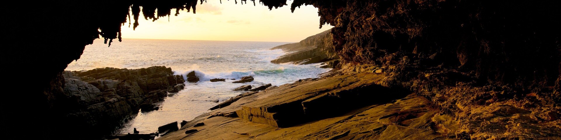 Admirals Arch featuring a sunset, caves and general coastal views