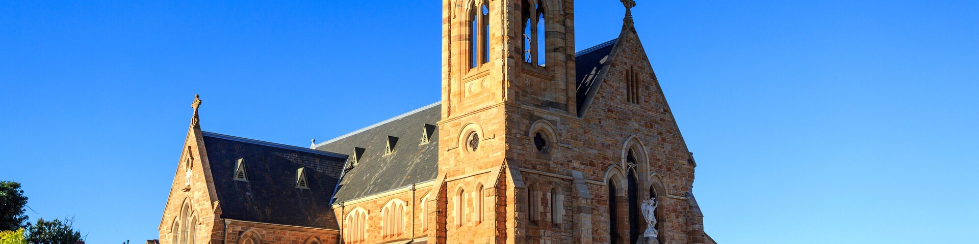 Uma igreja grande e histórica com uma torre imponente e janelas em arco.