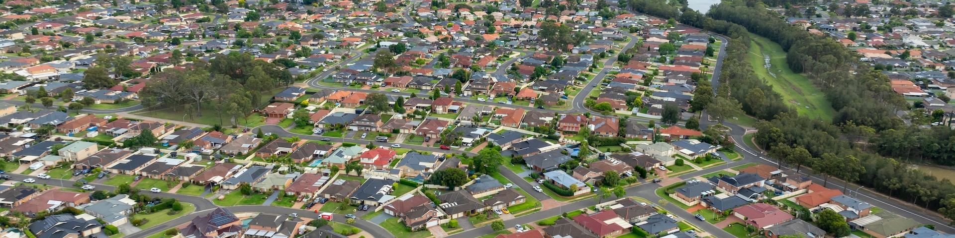 Área residencial com casas, ruas e um rio.