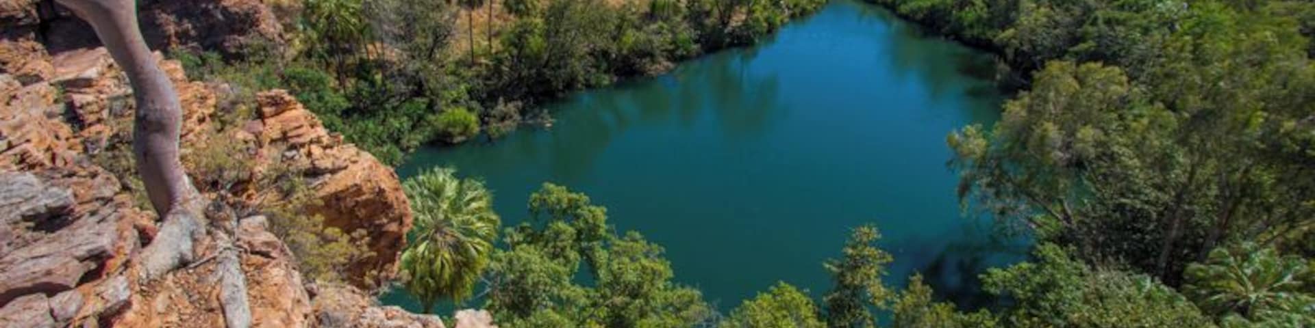 Um rio cercado por penhascos rochosos e vegetação densa.