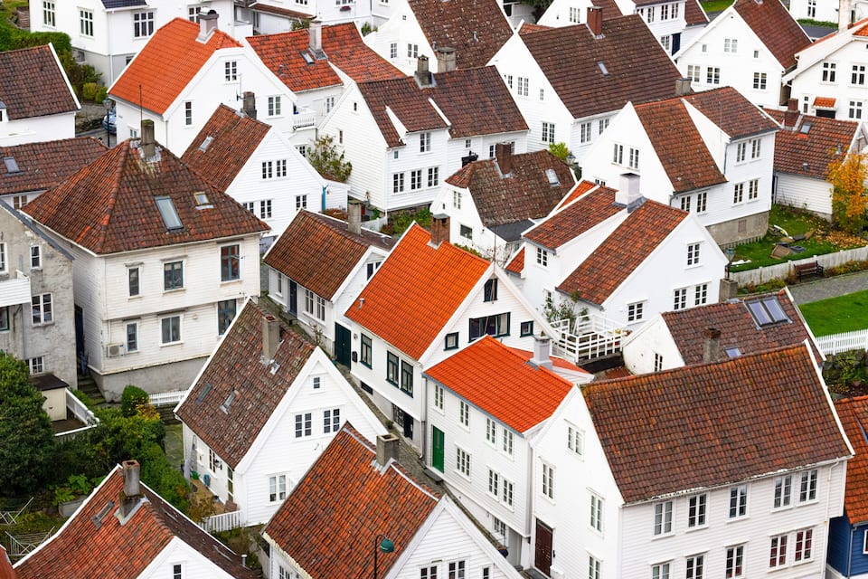 Um conjunto de casas brancas com telhados de telha vermelha.