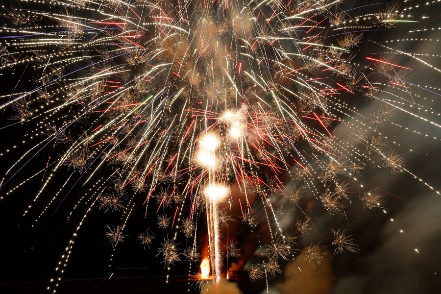 Fogos de artifício explodindo no céu noturno.
