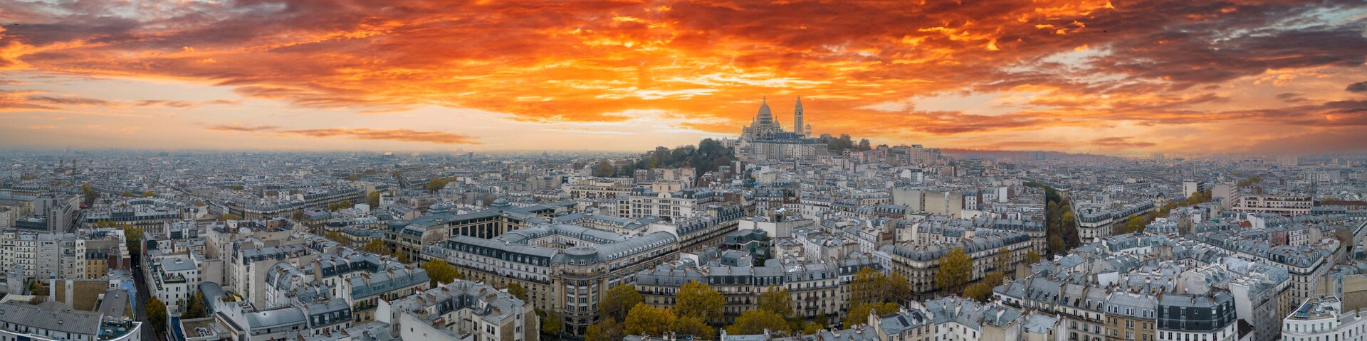 Paisagem urbana com uma torre imponente e céu ao pôr do sol.