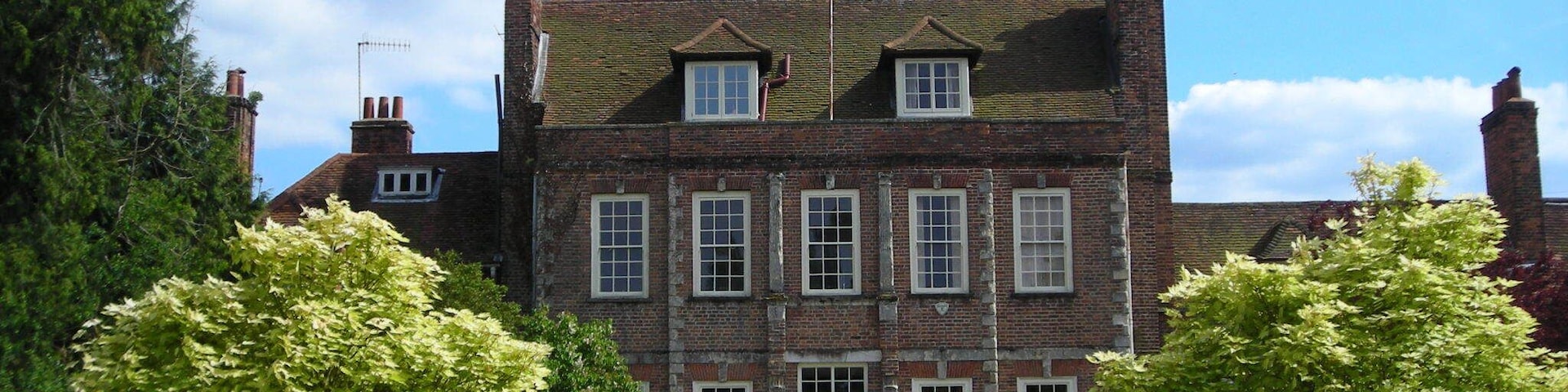 Byfleet Manor House. The current house was built in 1886 but a manor has been on the site since the 13th century. Once a residence of Queen Anne of Denmark, wife of James I, and a favourite haunt of the poet Geoffrey Chaucer, Byfleet Manor is now a private residence often used for location filming. It featured in ITV's Downtown Abbey as the home of Violet Crawley, Dowager Countess of Grantham, played by Dame Maggie Smith. In February 2013 the Surrey Advertiser reported how a telecoms engineer had lifted the floorboards and come across a previously undocumented seven-foot square hidden room beneath him. It had no doors and a bricked up window. The room's purpose remains unknown.