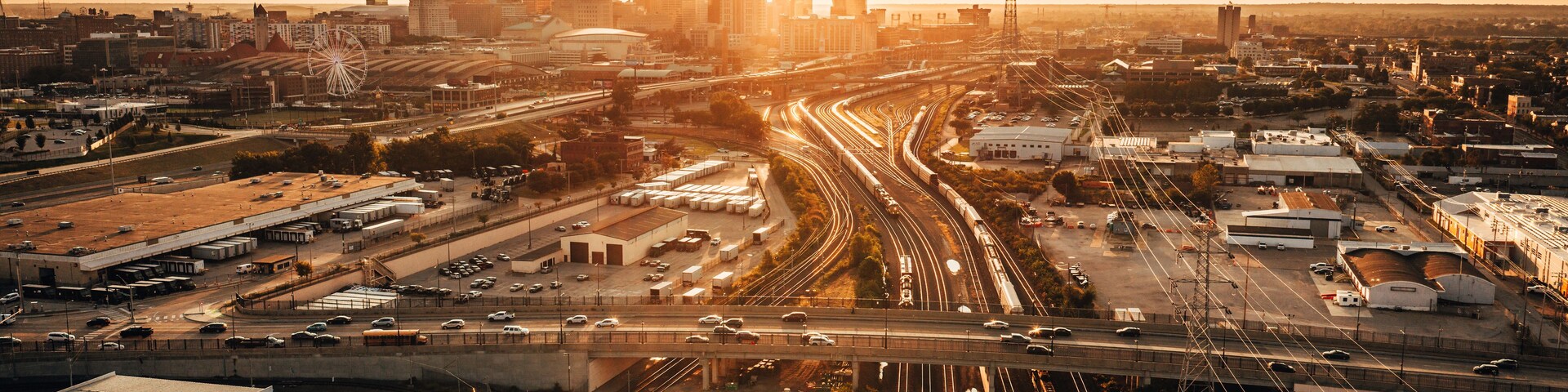 Paisagem urbana com uma ponte em arco imponente, várias autoestradas e edifícios industriais.