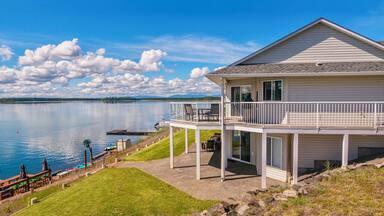 Uma casa à beira do lago com varanda com vista para a água.