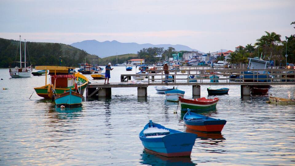 Cabo Frio mostrando uma cidade litorânea e uma baía ou porto assim como um homem sozinho