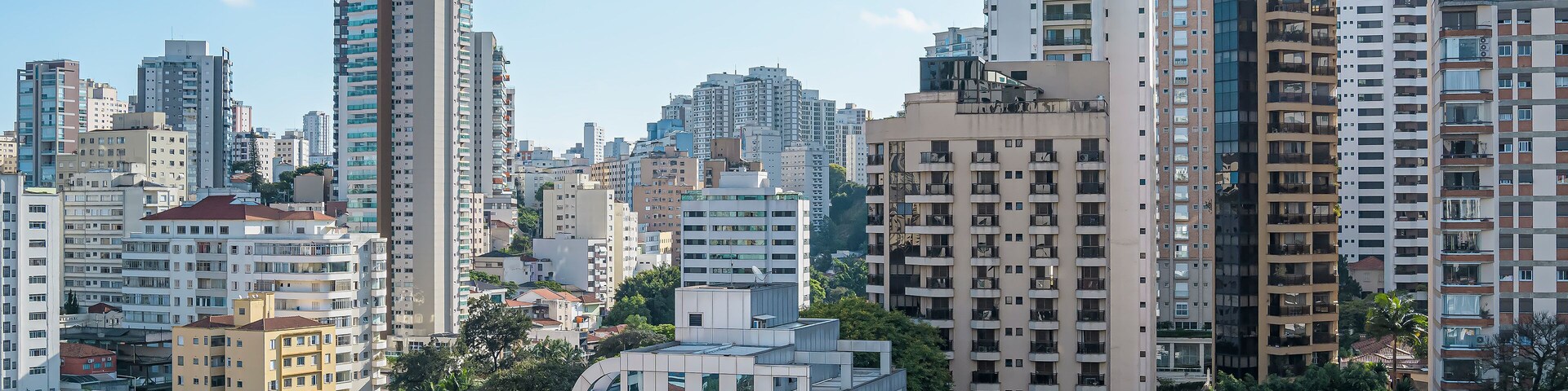 Paisagem urbana com arranha-céus, uma combinação de edifícios residenciais e comerciais, e áreas verdes.