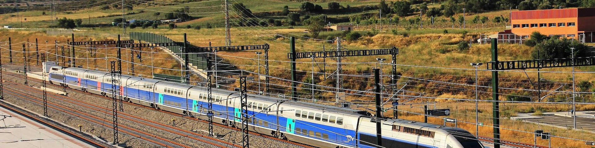 TGV llegando a la estación de Figueres - Vilafant. Detrás, en la colina de la derecha, el Castell de Sant Ferran.