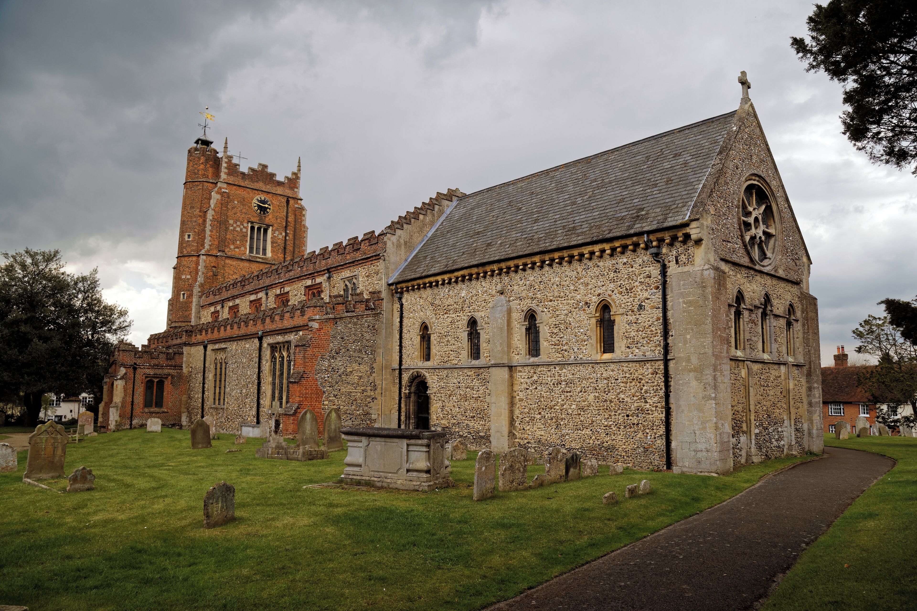 A south-east view of the churchyard, path, and Norman Romanesque chancel of St Nicholas' Church in Castle Hedingham in Essex, England. Camera: Canon EOS 6D with Canon EF 24-105mm F4L IS USM lens. Software: large RAW file lens-corrected, optimized and downsized with DxO OpticsPro 10 Elite, Viewpoint 2, and Adobe Photoshop CS2.