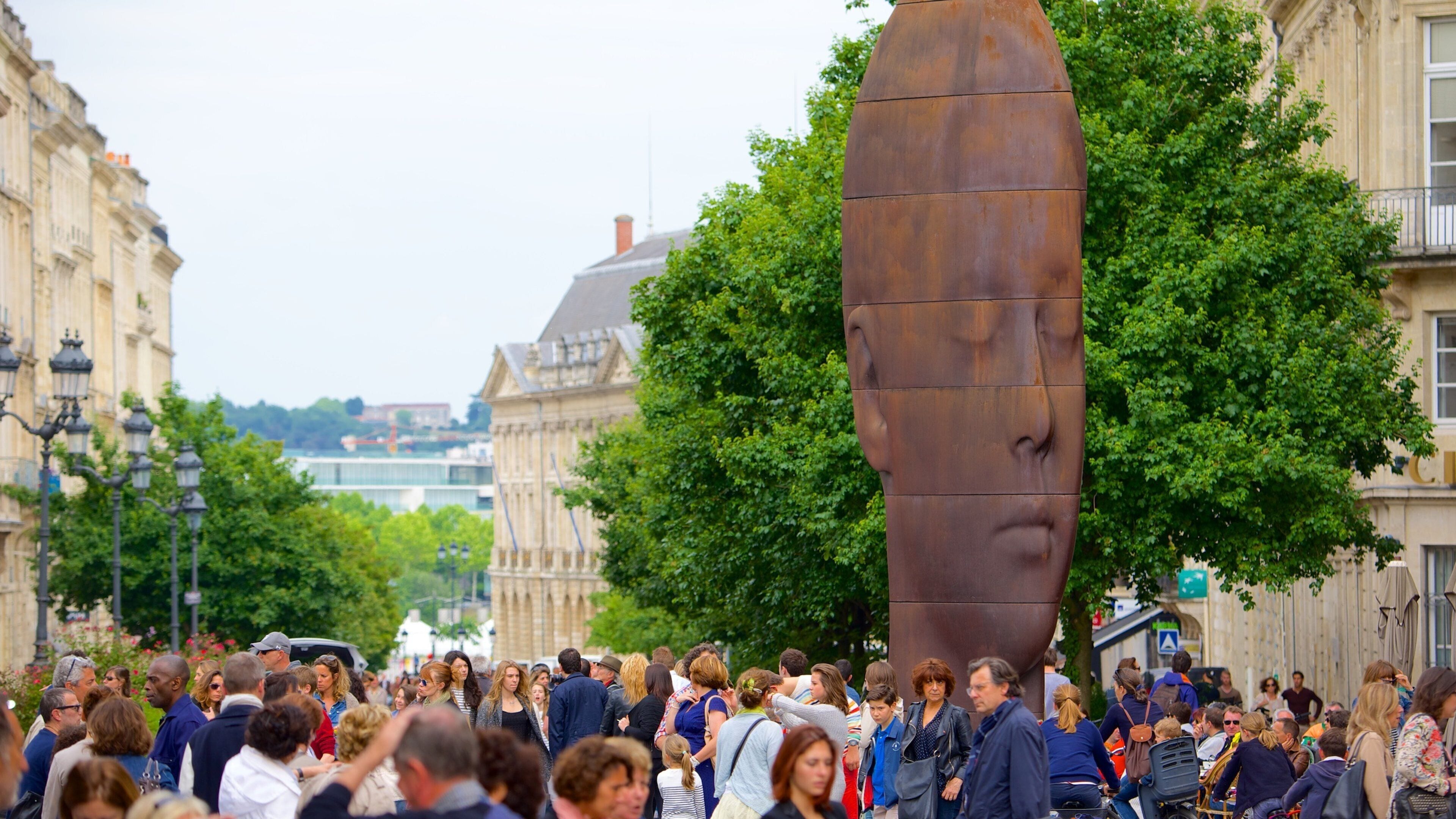 Place de la Comédie which includes outdoor art and street scenes as well as a large group of people