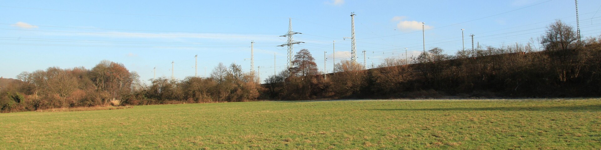 Hagen-Vorhalle: Blick vom namenlosen Wirtschaftsweg südwestlich des Hofs Niederste Hülsberg über eine Wiese in Richtung Nordosten, rechts der Bahndamm im Vorfeld des Rangierbahnhofs Vorhalle, ganz links im Hintergrund der Kaisberg; abgebildeter Bereich (bis zum Bahndamm) gelegen im Landschaftsschutzgebiet „Ruhraue/Auf der Bleiche“