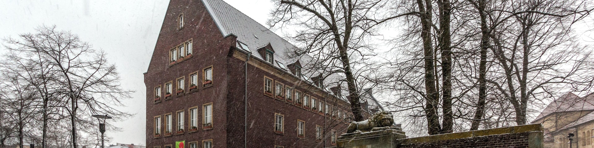 Town Hall and war memorial while snow falls, Dülmen, North Rhine-Westphalia, Germany