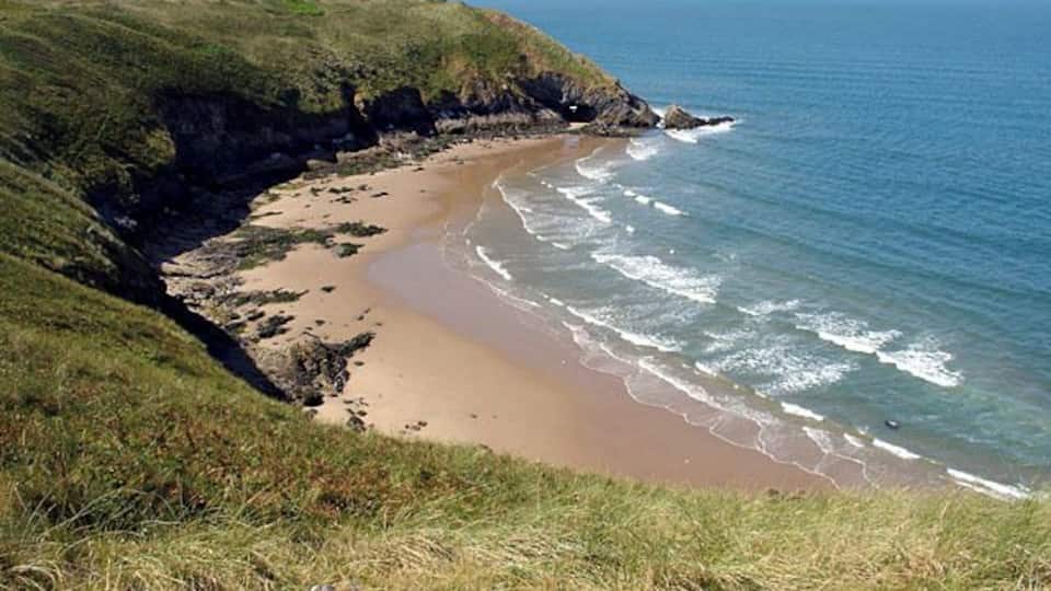 Llangennith Sands and the Three Chimneys cave. Looking down onto Llangennith Sands to the western end of the bay where the Three Chimneys Cave is.