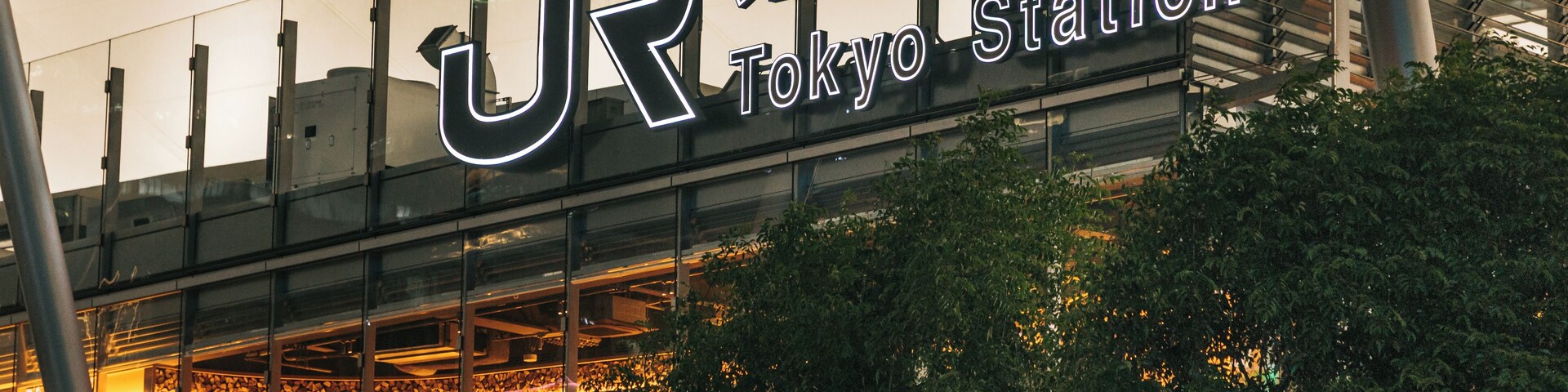 Um edifício moderno com um letreiro grande 'Tokyo Station'.