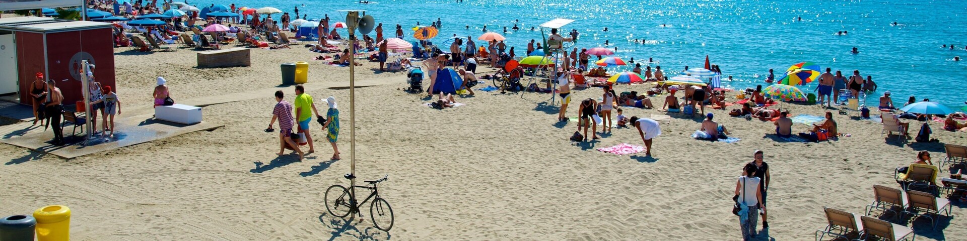 Llevant Beach which includes a sandy beach and general coastal views as well as a small group of people