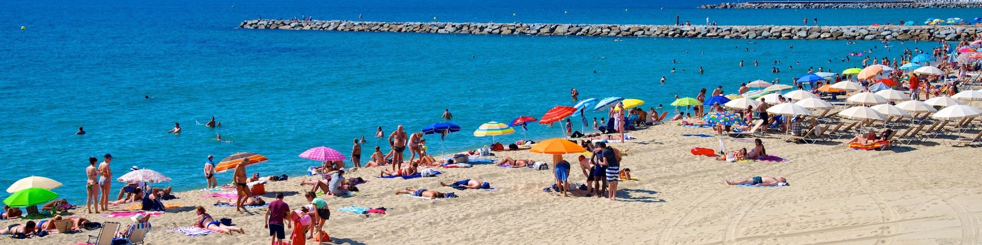 Barcelona showing a sandy beach as well as a large group of people