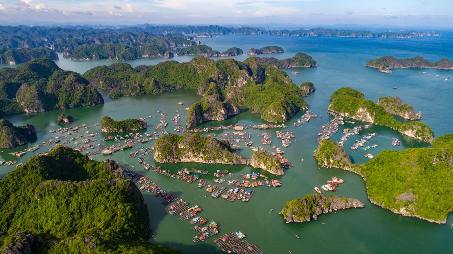 Vista aérea de uma área costeira com inúmeras ilhas pequenas e um conjunto denso de barcos e cais.