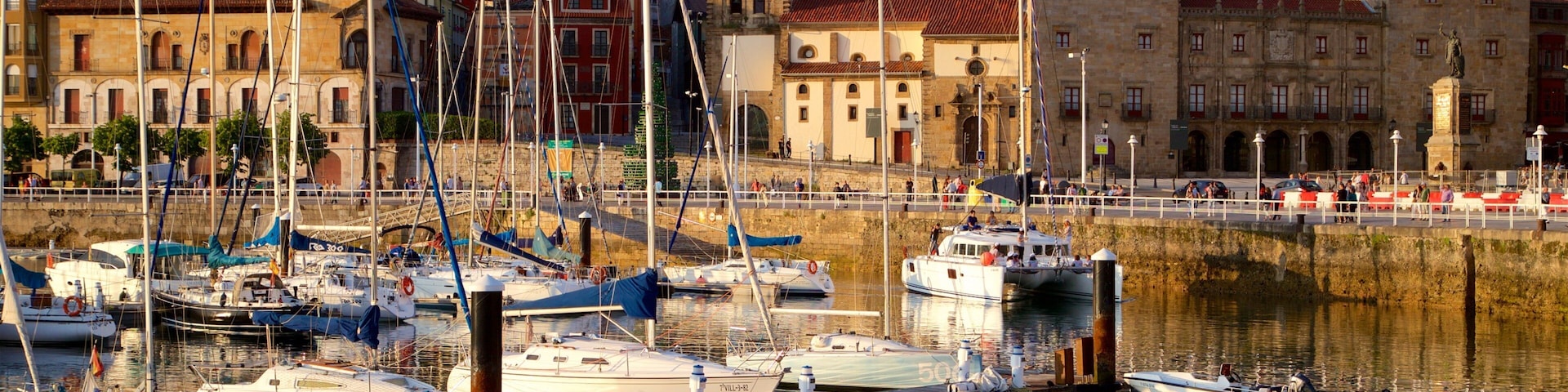 Gijón caracterizando uma baía ou porto, um pôr do sol e uma cidade