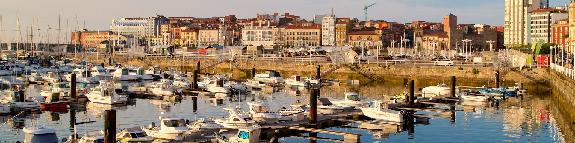 GijĂłn que inclui um pĂŽr do sol, uma cidade e uma baĂa ou porto