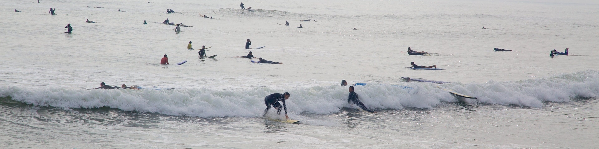 Lima featuring surfing and waves as well as a large group of people