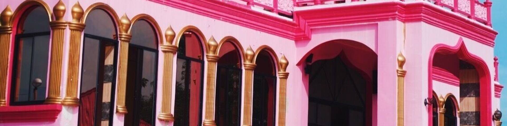 In the Philippines, specifically in Datu Saudi Ampatuan, Maguindanao, a noteworthy mosque that stands for peace has become quite a spectacular attraction. Can you guess what color? Yes. This is the Pink Mosque, or formally called, Masjid Dimaukom.
Masjid Dimaukom is clad in vibrant shades of pink – from the carnation-colored walls adorned by golden arches of its glass windows, to the lively cerise domes accented with silver spires, as well as silver star and crescents that face east. But that’s not it. The spacious interiors dominated by pink hues from its walls to the high ceilings, the shiny carmine of the tiled flooring, the bold golden pillars – the inside is equally captivating. This edifice is certainly an eye candy from inside out.
Beyond the structure’s aesthetic appeal, the Pink Mosque was built, primarily, as a sacred place of prayer, and also a symbol of peace. A unique structure that exemplifies harmony among Filipinos, regardless of religion, ethnicity, culture, and social class. The mosque is a brainchild of a man who believes in his love for the country, its people, and above all, the love for Allah.