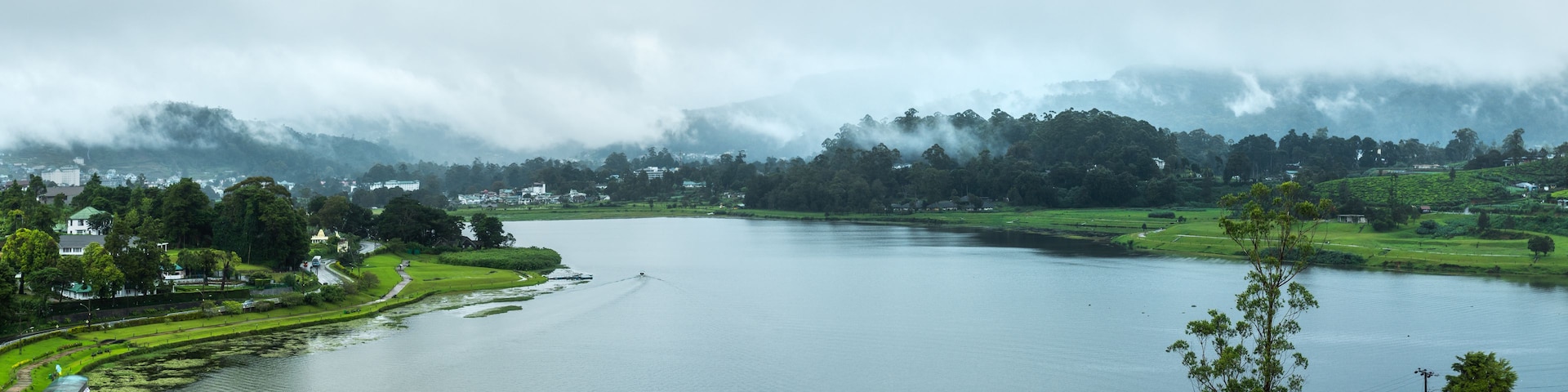 Um rio serpenteando por uma paisagem verde com edifícios e árvores.