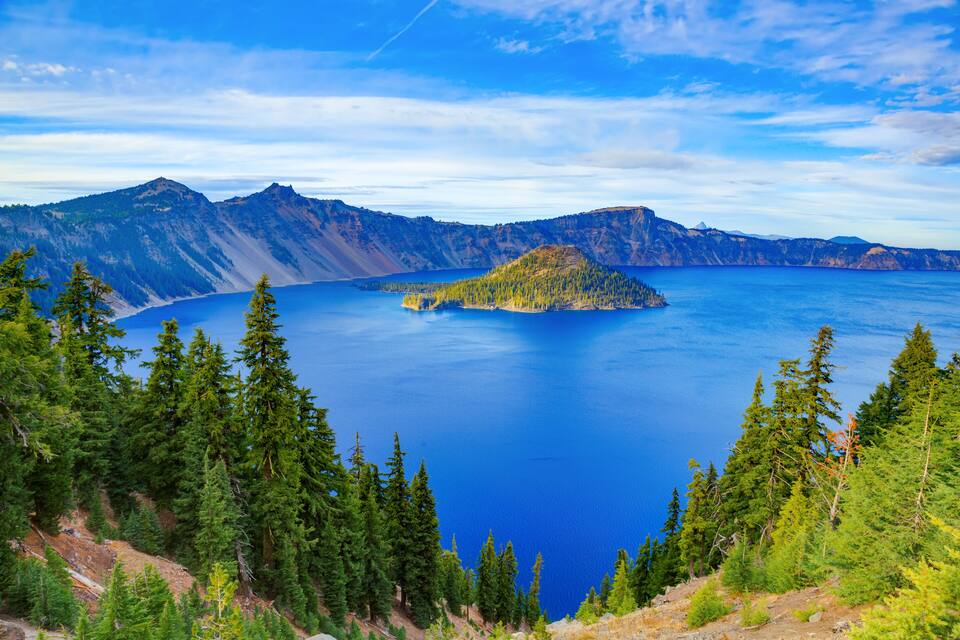 Um lago rodeado por montanhas e florestas densas.