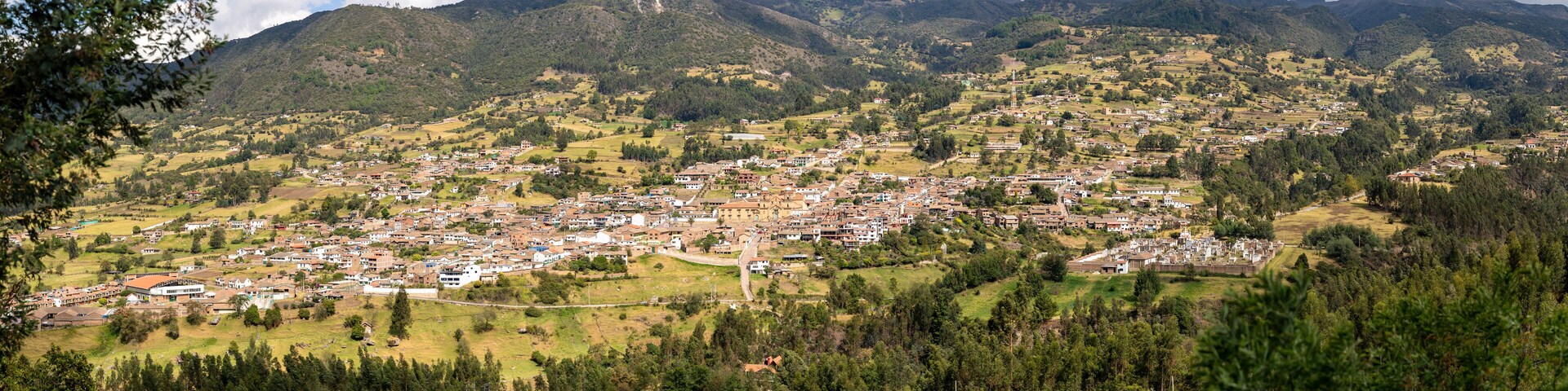 Uma cidade situada num vale, com montanhas ao fundo.
