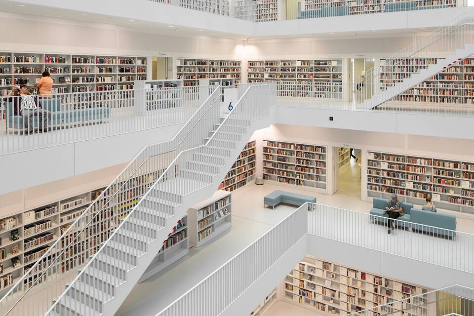 Uma biblioteca com vários níveis, estantes, escadas e áreas de estar.