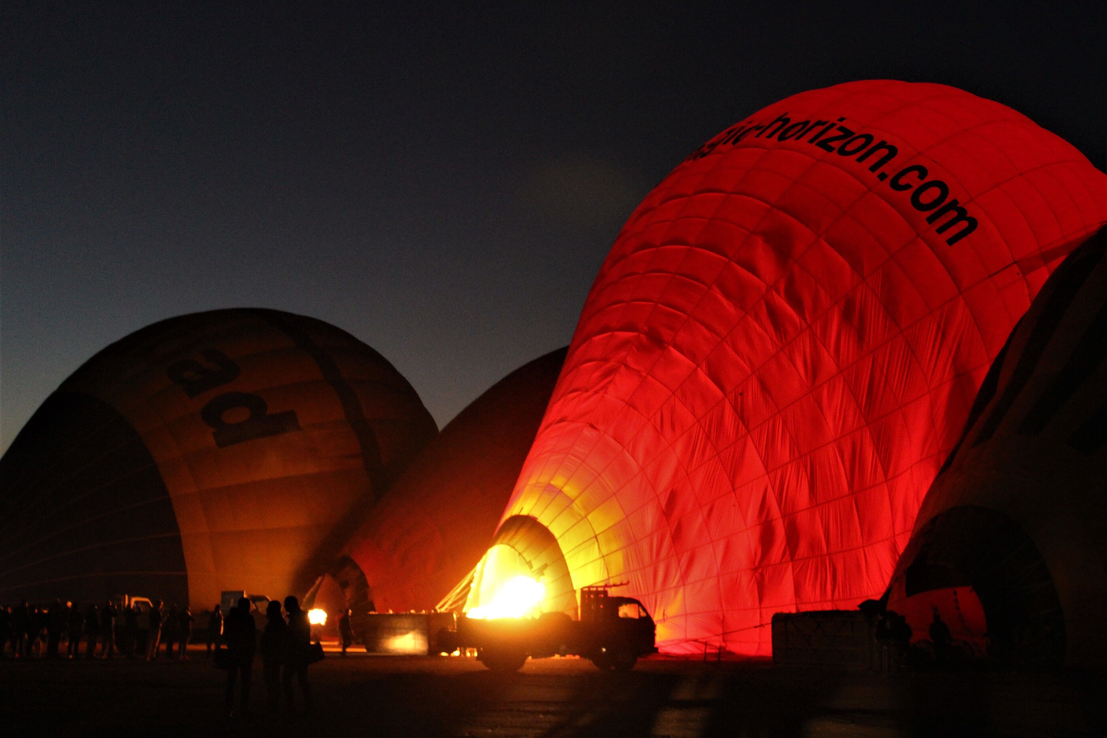 Um balão de ar quente com 'horizon.com' escrito nele, e outro balão com 'pa' visível.