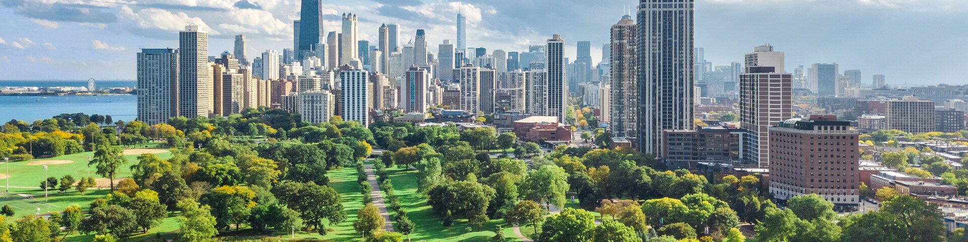 Paisagem urbana com um grande corpo d'água, áreas verdes de parque e edifícios altos.