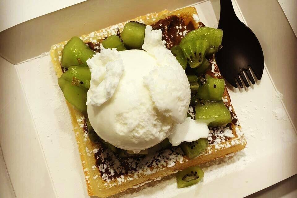 Sobremesa com gelado e fatias de kiwi numa gaufre.