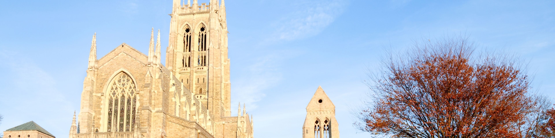 Uma catedral grande com uma torre alta e um edifício menor ao lado.