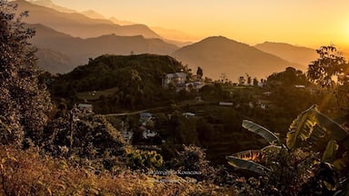 Paisagem montanhosa com uma aldeia ao pôr do sol.