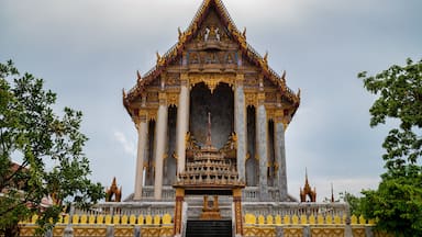 Um templo tradicional tailandês com decorações douradas elaboradas e um santuário central.