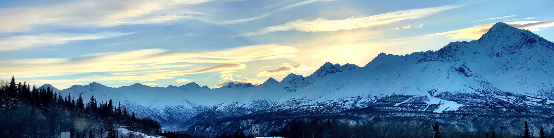 Cordilheira nevada com uma estrada sinuosa que a leva.