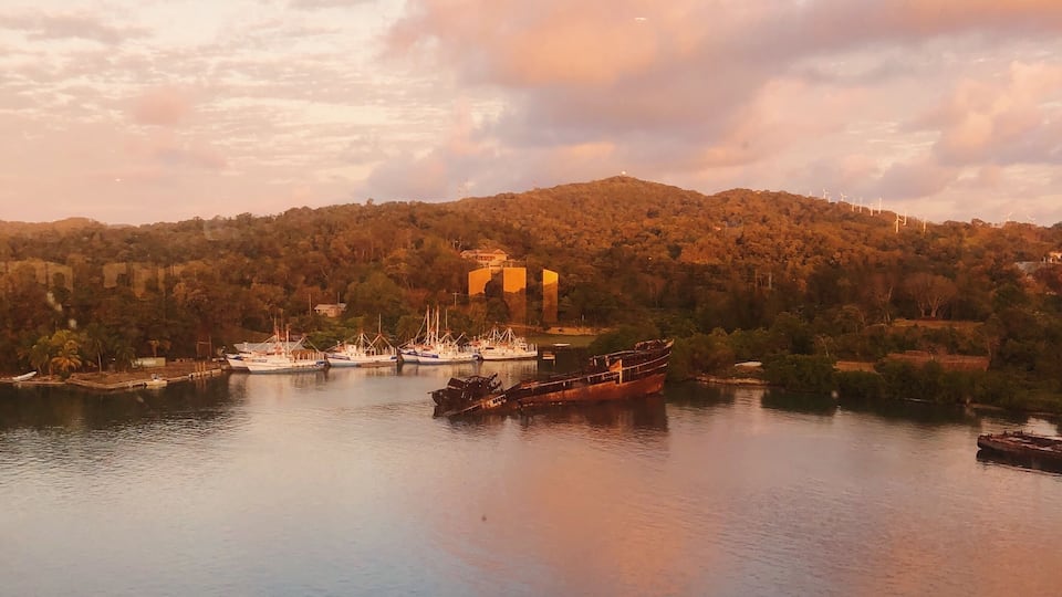 A beautiful sunrise and view of a shipwreck overlooking Mahogany Bay, Honduras #honduras #roatan #mahoganybay #shipwreck #island #ocean #sunrise #tropicalforest #Caribbean #Adventure