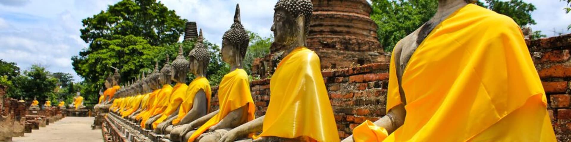 Fileira de estátuas de Buda sentadas em um pátio de templo.