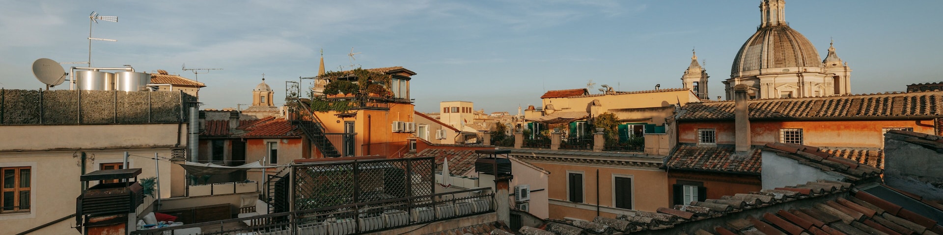 Paisagem urbana com edifícios históricos, uma cúpula imponente e telhados de terracota.
