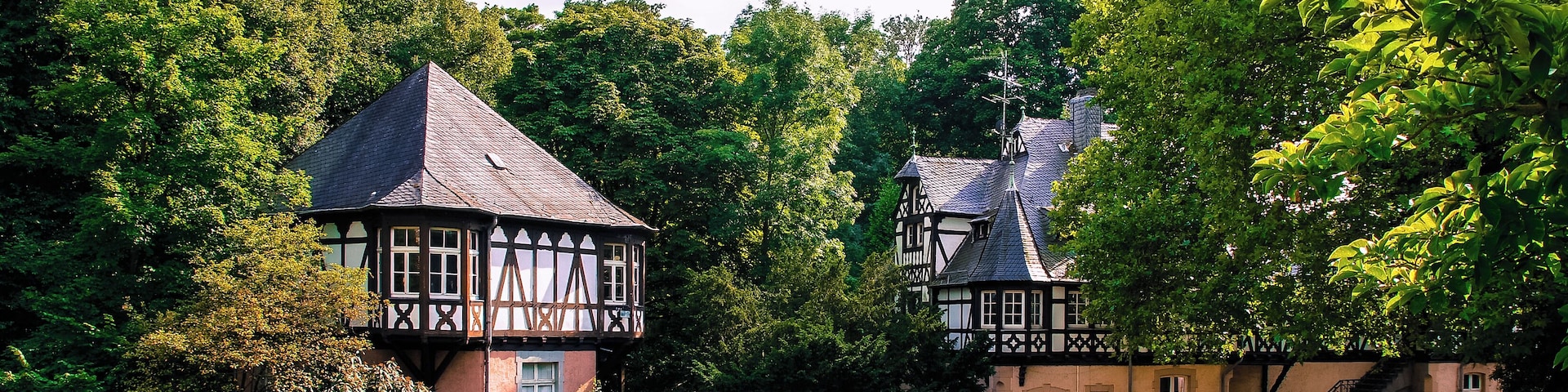 Mittelalterliche Wasserburg, die im neunzehnten Jahrhundert durch Luise Prinzessin von Preußen zum Schloss mit englischen Park umgestalltet