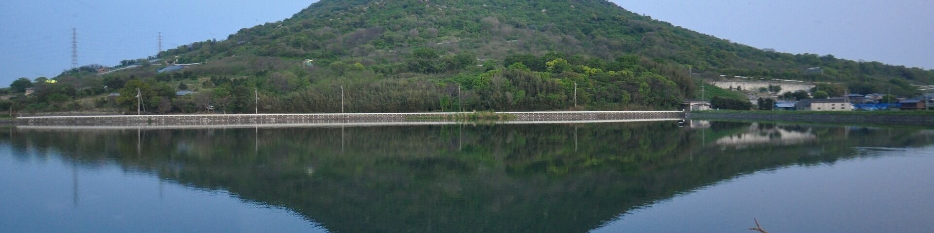 Um lago calmo com uma montanha ao fundo.