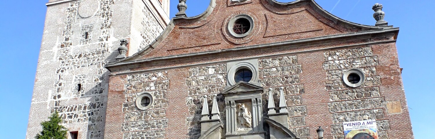 Uma igreja histórica com uma torre de sino e uma grande porta de madeira.