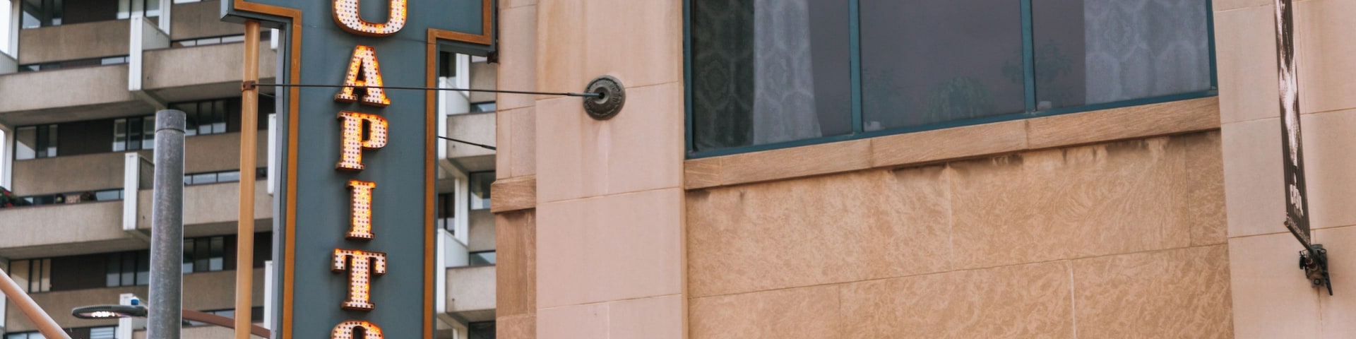 Placa de teatro com o nome 'THEATRE CAPITOL' fixada em um edifício.