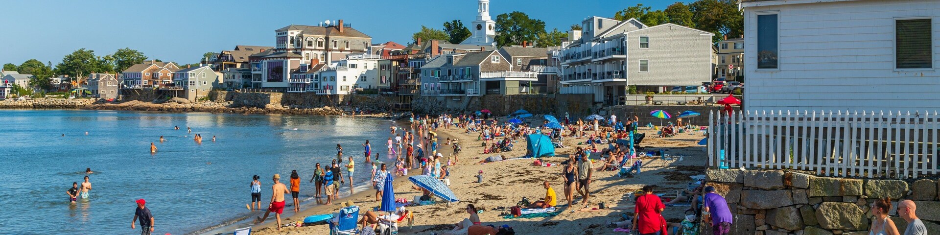 Front Beach featuring a beach and a coastal town as well as a large group of people