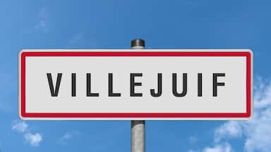 Placa de rua com a palavra 'VILLEJUIF' contra um céu azul límpido.