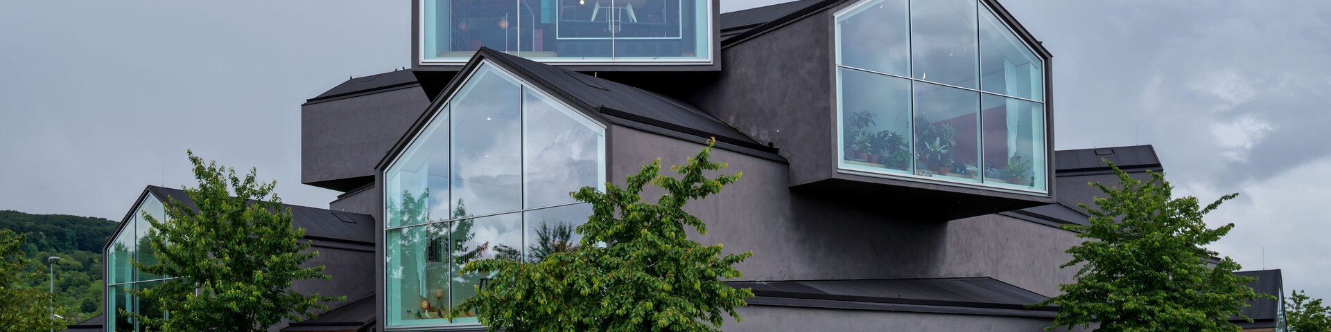 Um edifício moderno com grandes janelas de vidro e um design geométrico singular.