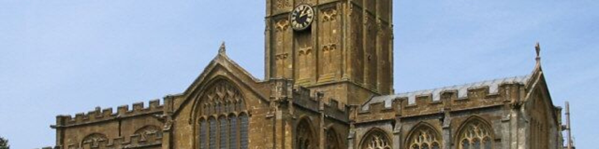 Uma igreja histórica com uma torre alta e janelas em arco.